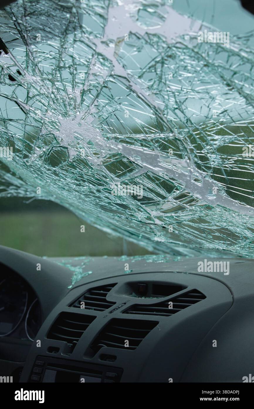 Damaged car interior showing cracked windshield and green-tinted glass ...