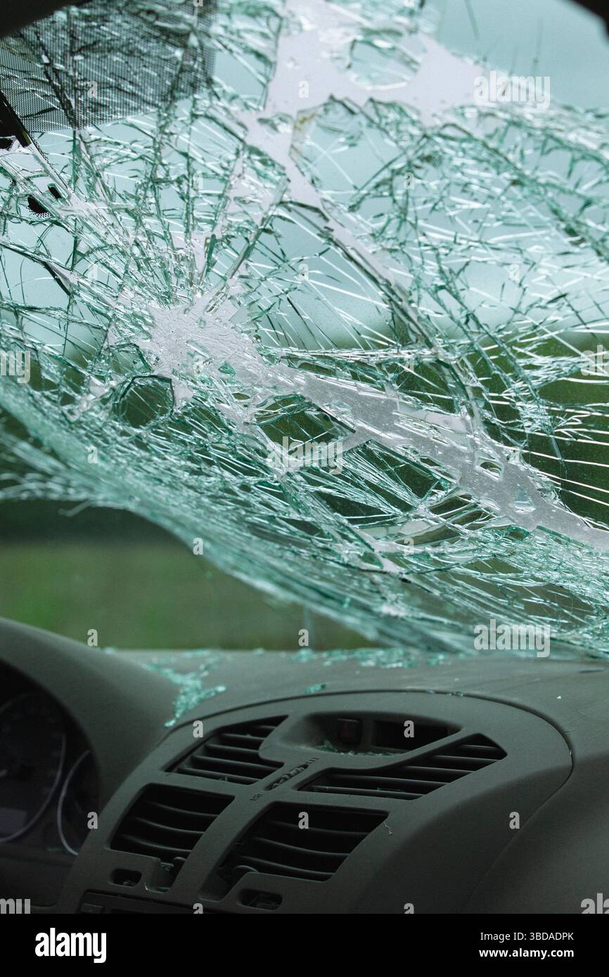 Damaged car interior showing cracked windshield and green-tinted glass ...