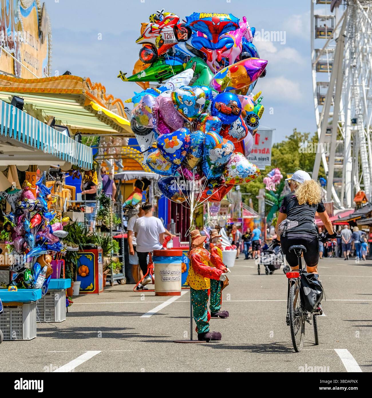 The image captures a vibrant fairground scene. A clown in a colorful ...