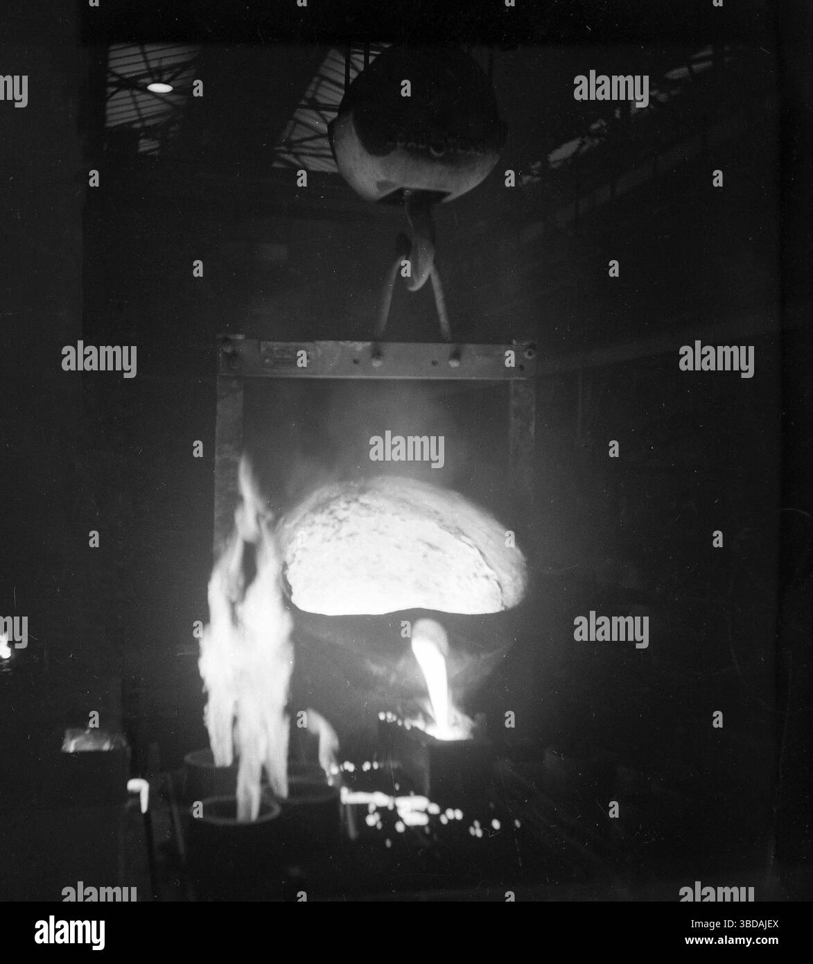 1950s, historical, inside an ironworks, molten iron being poured into a ...