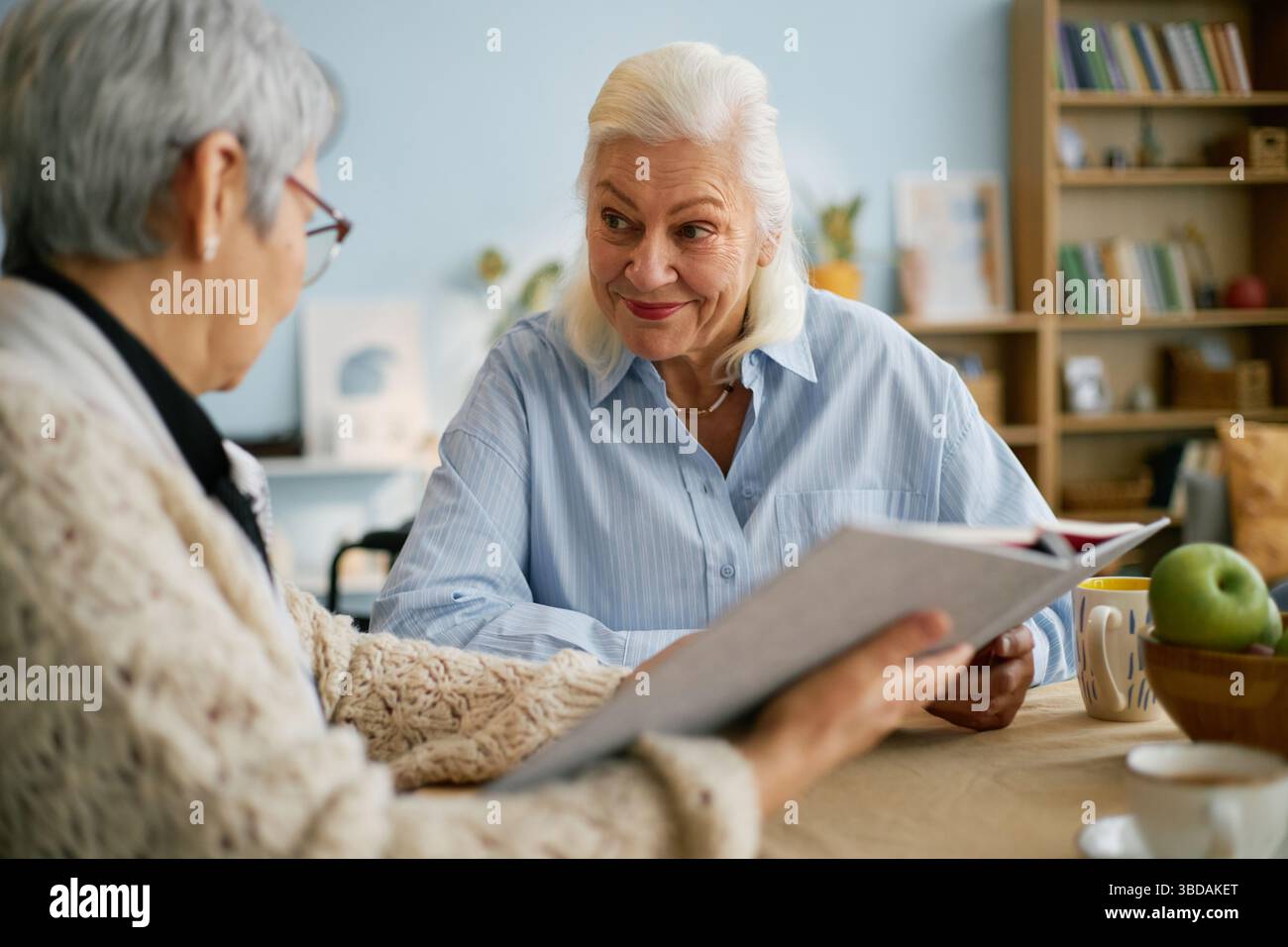 Senior Women Enjoying Conversation While Reading Book Stock Photo - Alamy