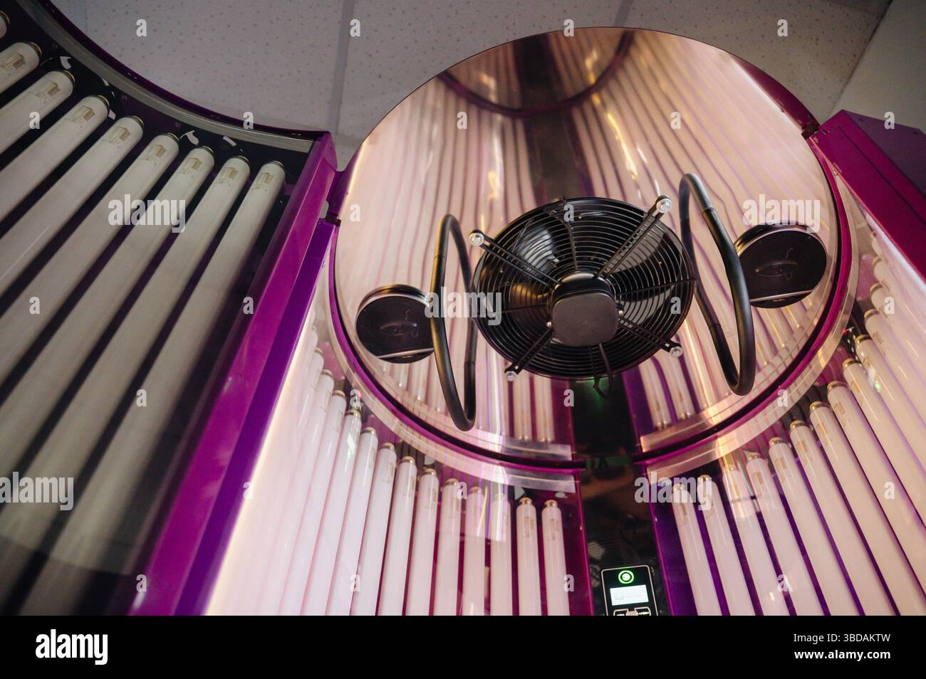 Solarium cabin with glowing UV lamps and control buttons, tanning ...