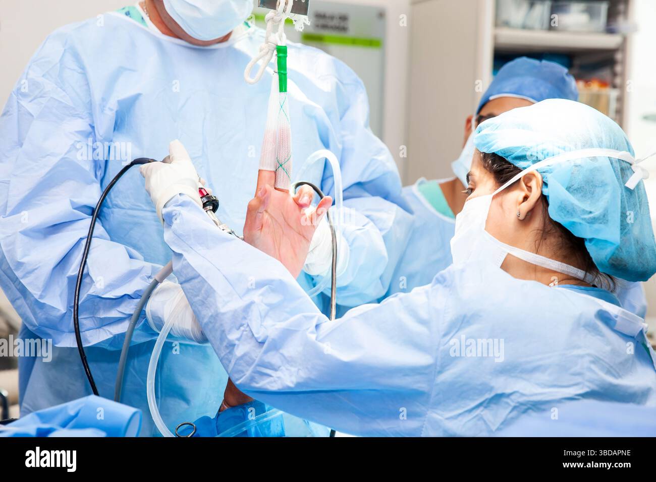 Group of orthopedic surgeons performing a wrist arthroscopy on a male ...