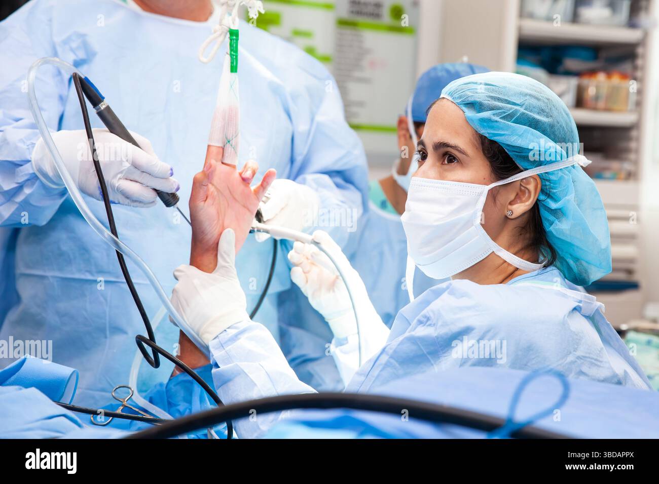 Group of orthopedic surgeons performing a wrist arthroscopy on a male ...