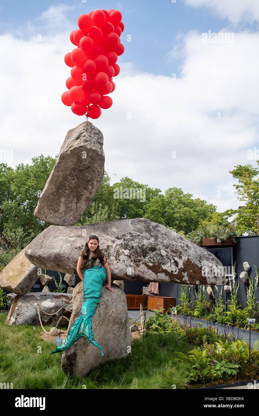 Chelsea, London, UK. 19th May, 2025. A child dressed as a mermaid sits ...