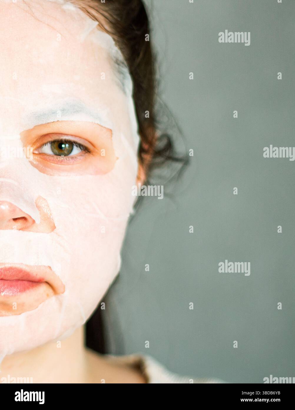 Close up vertical image of female with hydrating sheet mask, showcasing ...