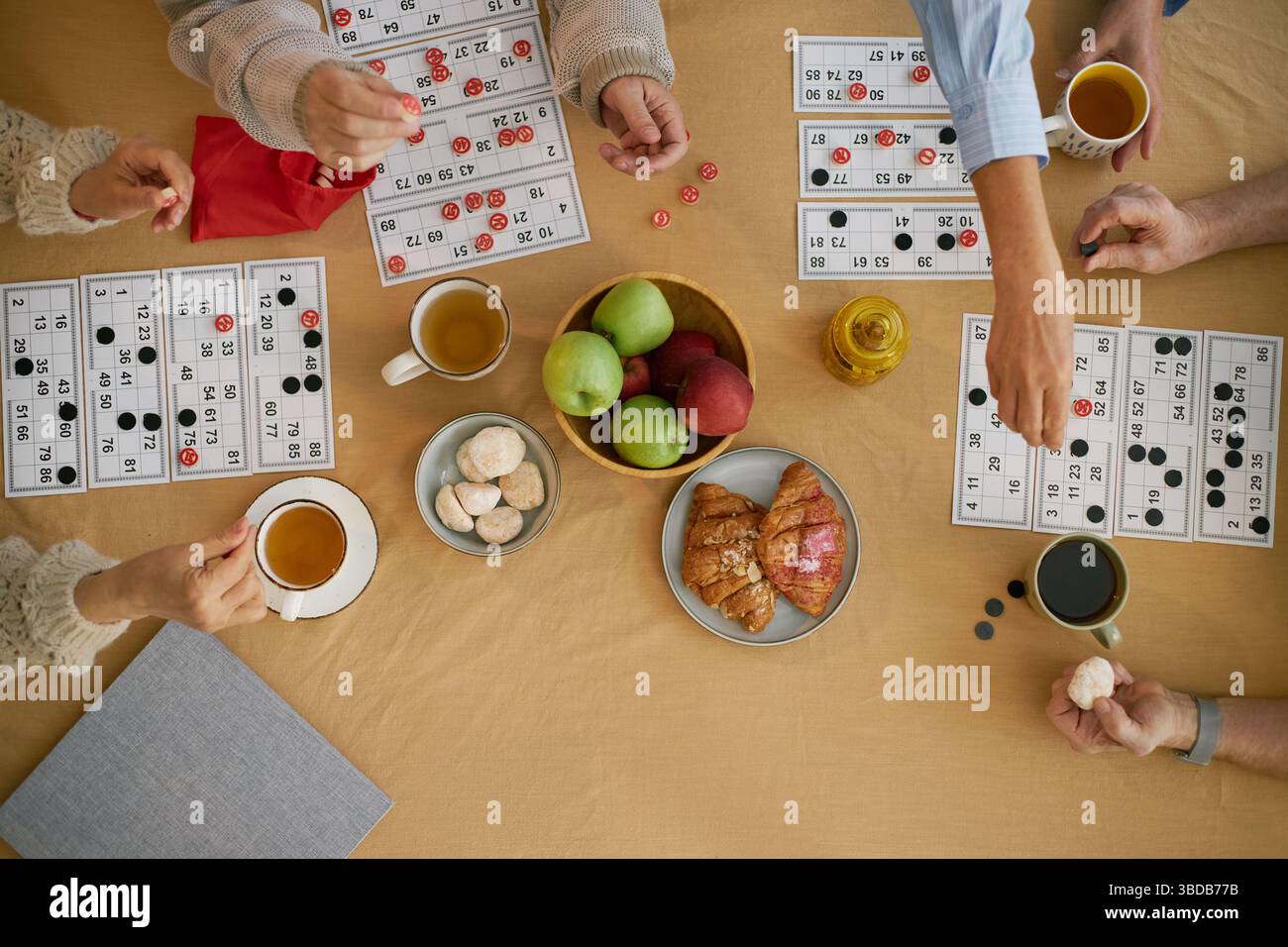 Playing Bingo Around Table with Drinks and Snacks Stock Photo - Alamy