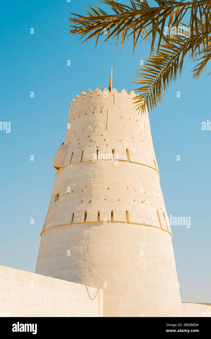 Stone arabic watchtower with waving United Arab Emirates National Flag ...