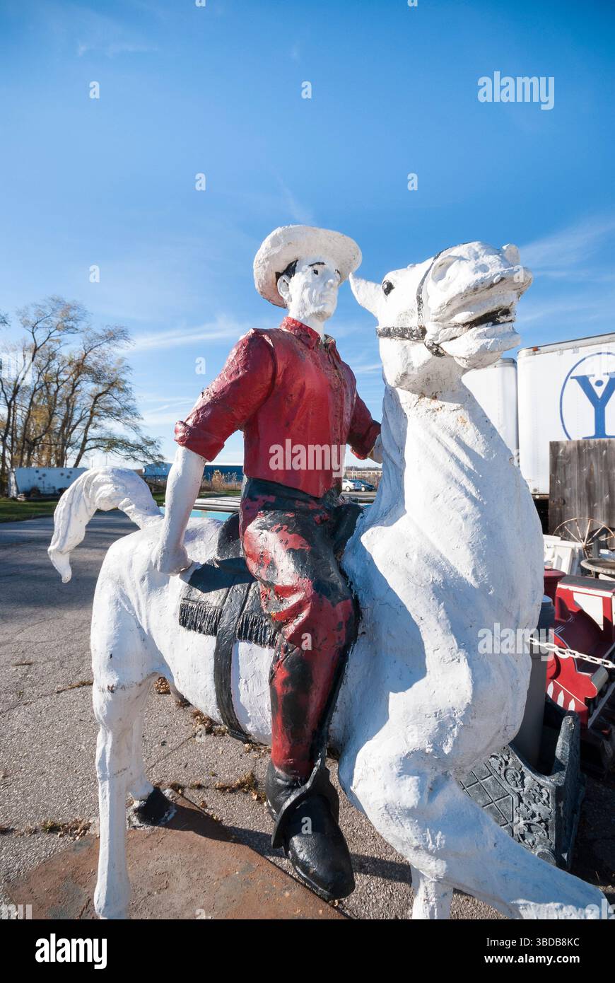 A strange and weathered fiberglass life-sized sculpture of a cowboy ...