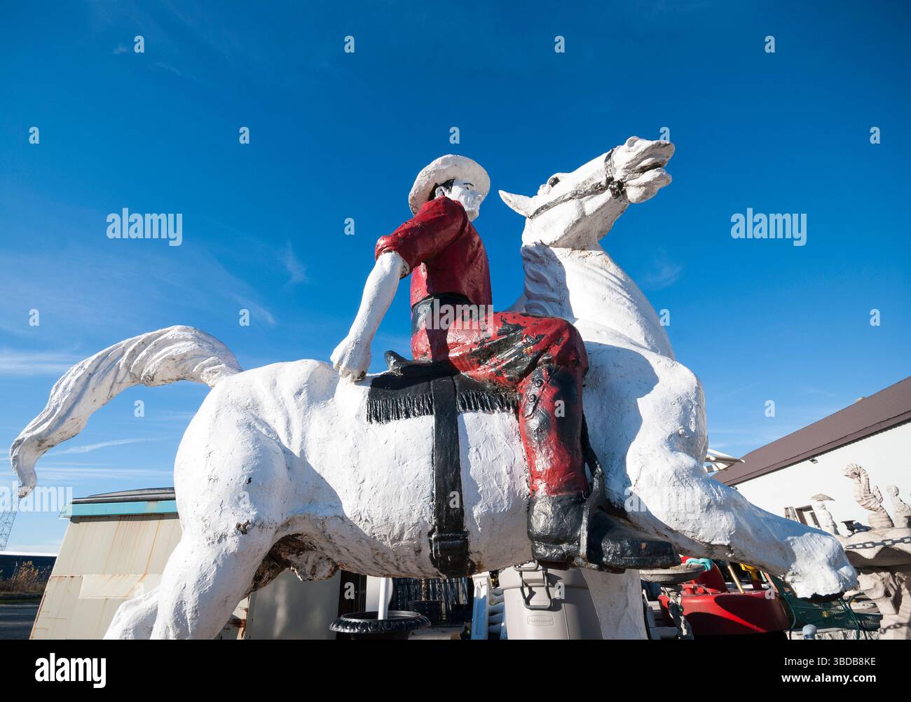 A strange and weathered fiberglass life-sized sculpture of a cowboy ...