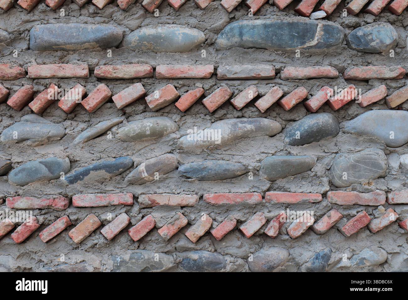 Intricate wall design features alternating stone and brick patterns ...