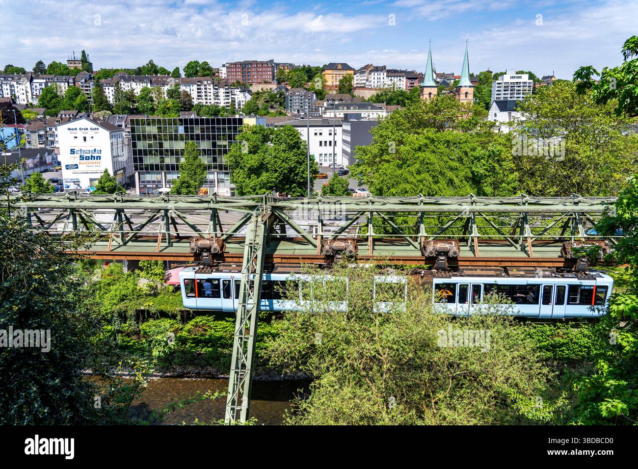 Wuppertal suspension railway train travelling along the Wupper river, at the Hauptbahnhof ...