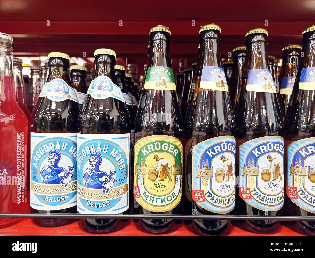 Assorted beer bottles on supermarket shelf displayed in store aisle ...