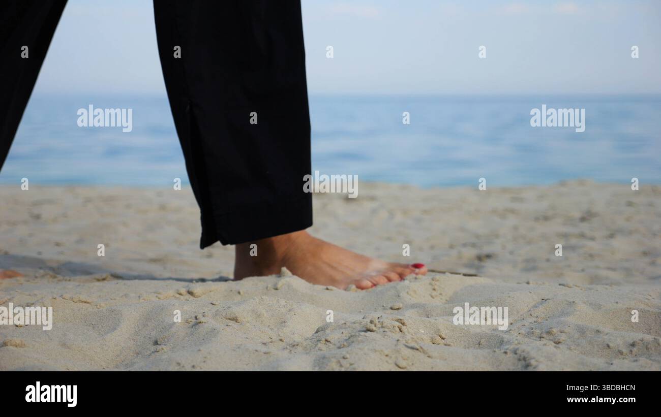 Legs of adult woman stepping along sea shore. Female feet walking on ...