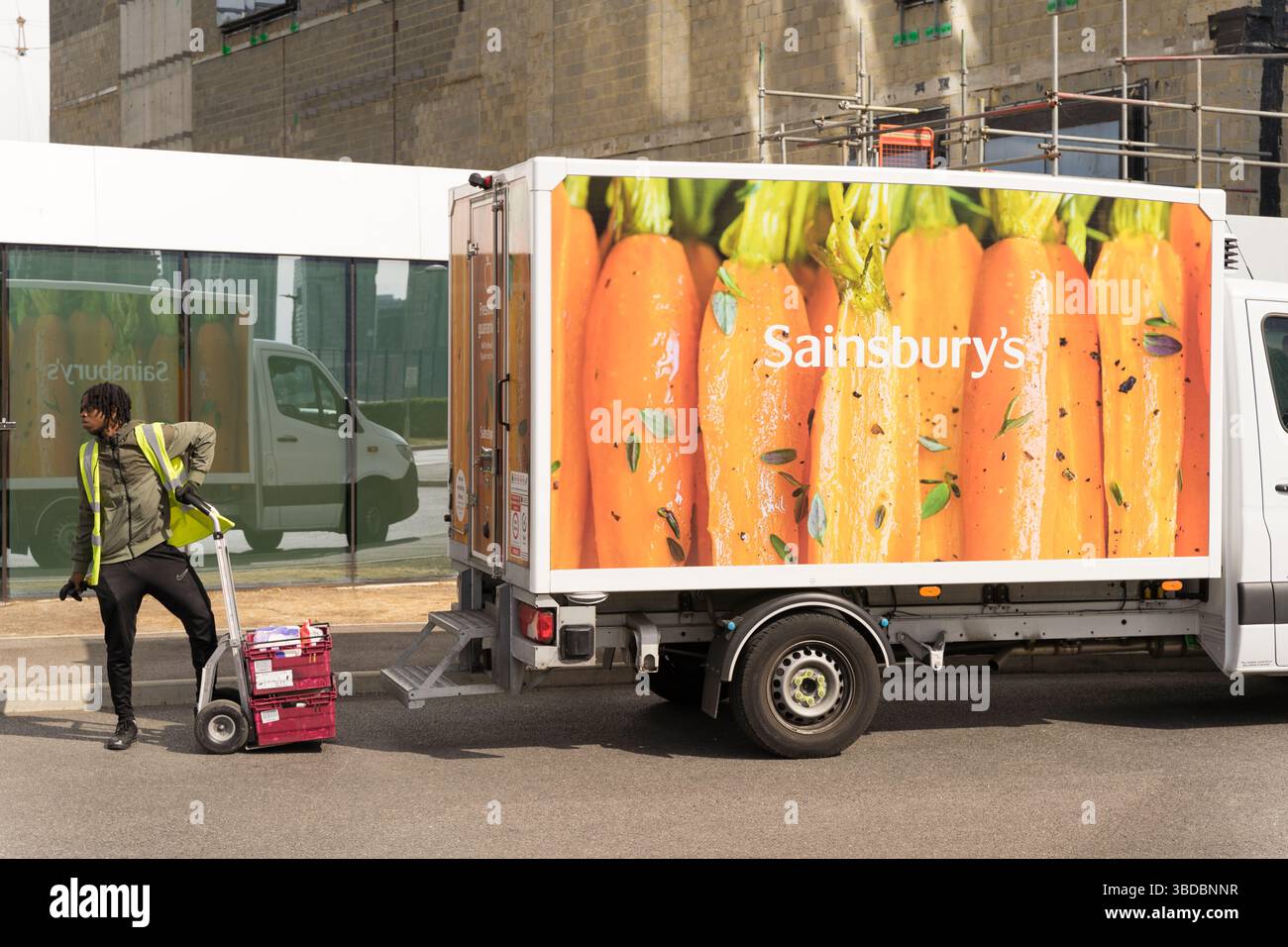 Sainsbury's groceries delivery man loads trolley with shopping for home ...
