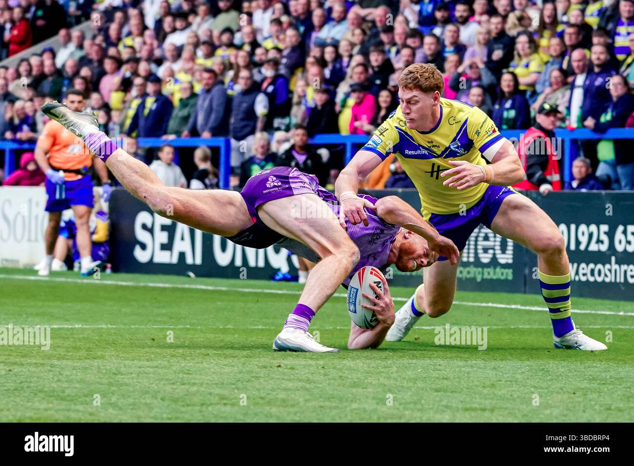 WARRINGTON, ENGLAND - MAY 23: Joe Burgress is tackled by Dan Russell ...