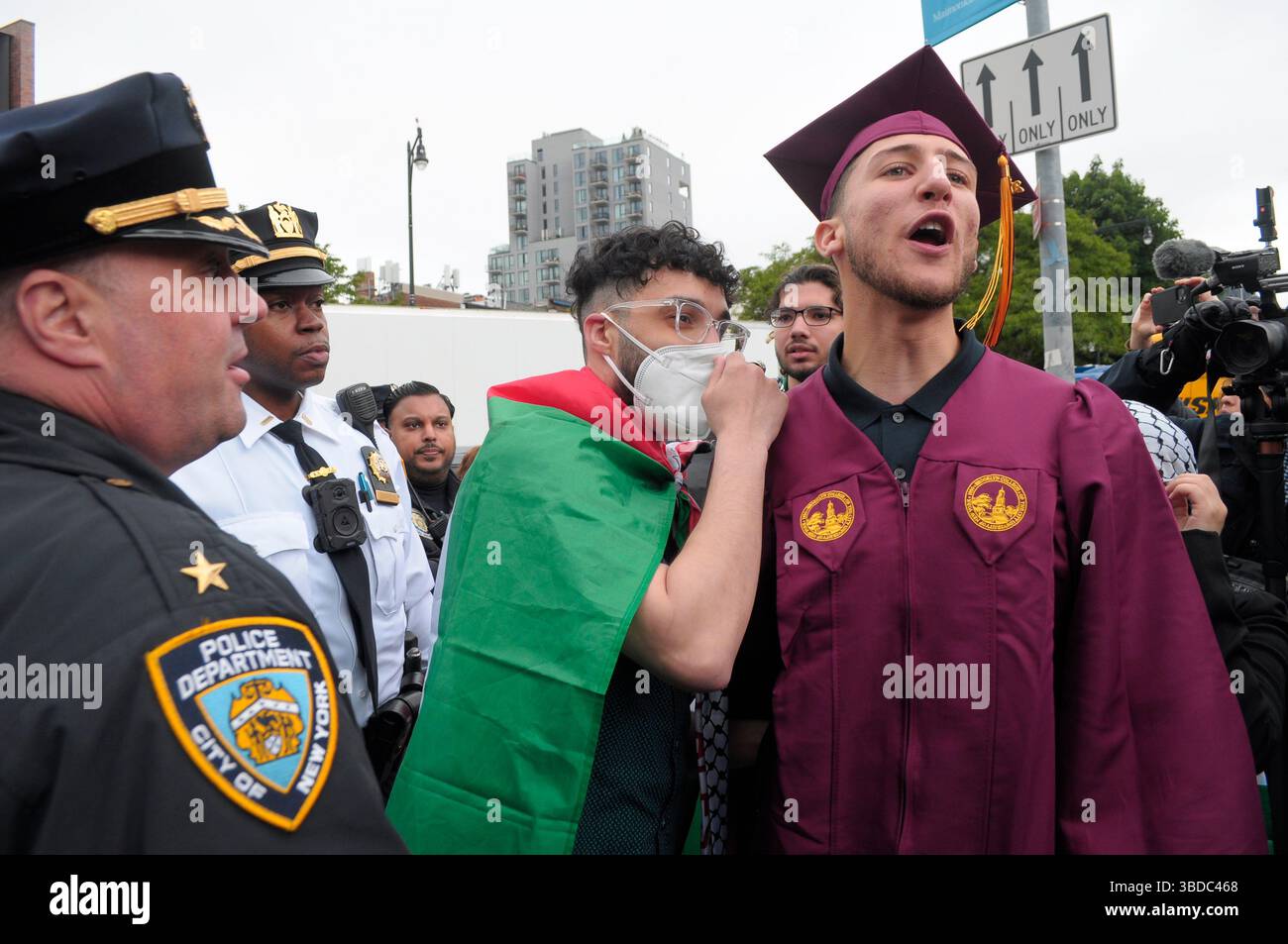 A graduating student wearing a graduation cap and gown speaks at a pro ...