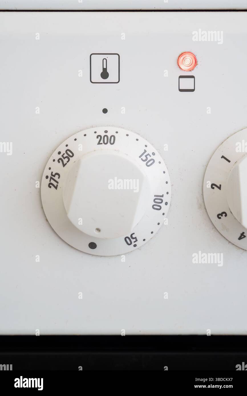 Close-up of oven control dial set to 200 degrees with indicator light ...