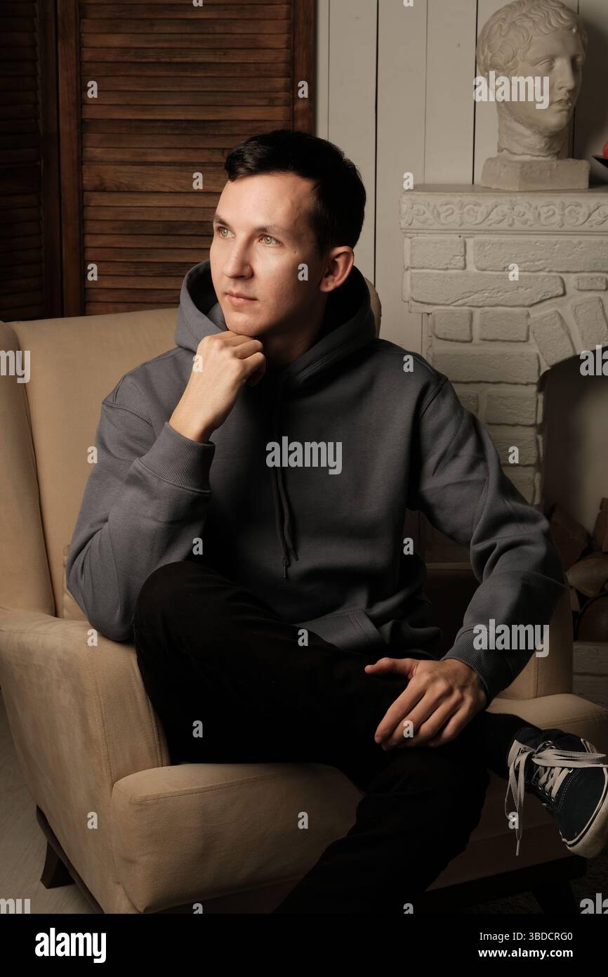 A Contemplative Young Man Dressed in Modern Fashion is Seated ...