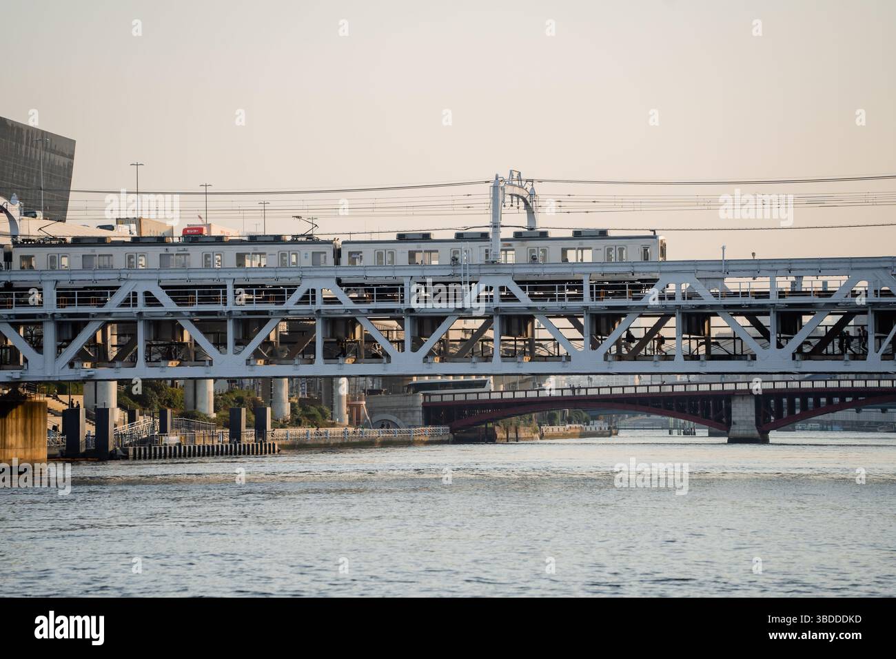 Asakusa, Tokyo, Japan 03-23-2025: Train and people crossing the river ...