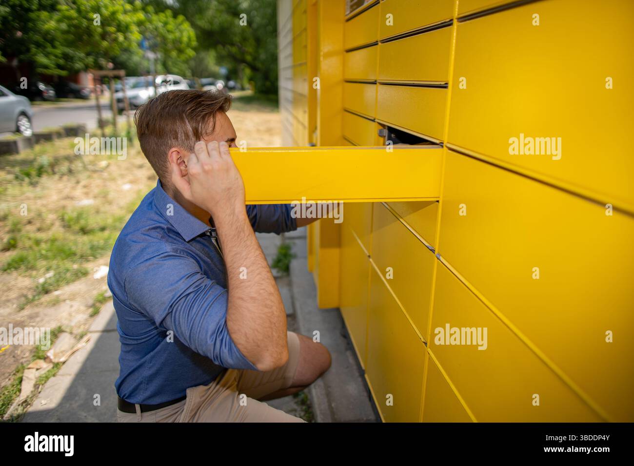 A man is utilizing a modern parcel locker system to conveniently ...