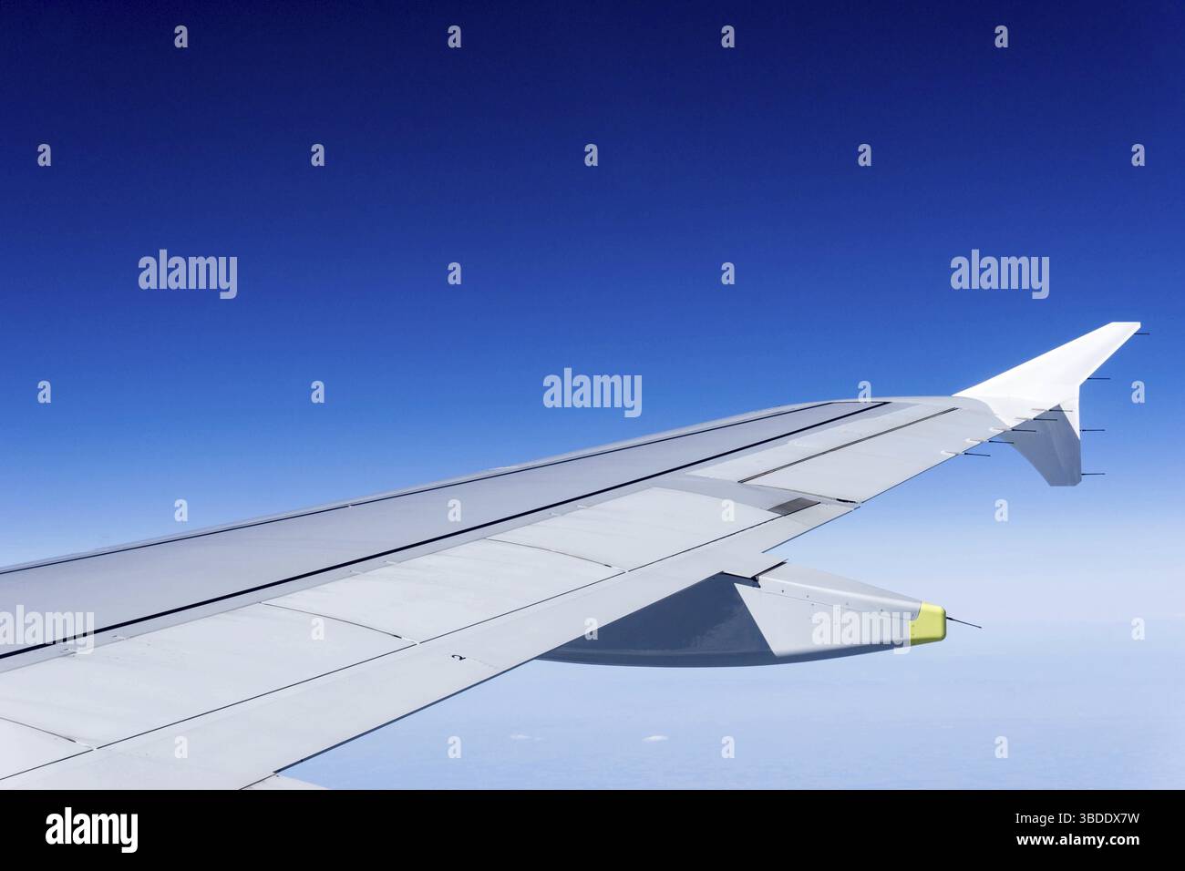 metal airplane wing in blue sky during flight in a deep blue sky above ...