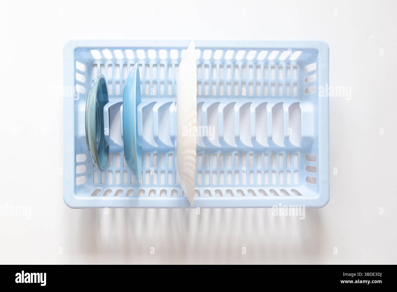 Plates in a blue plastic dish drainer in the kitchen, top view ...