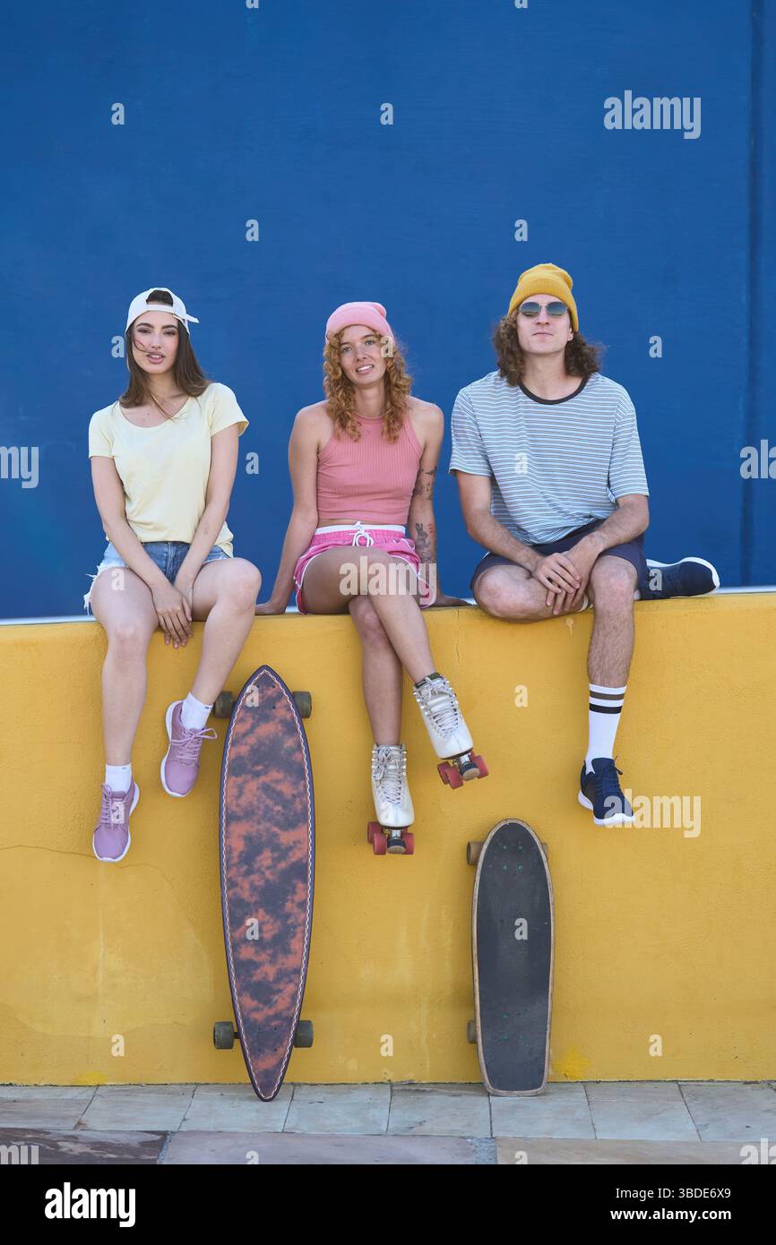 Group of young skaters posing with their skateboards and roller skates ...