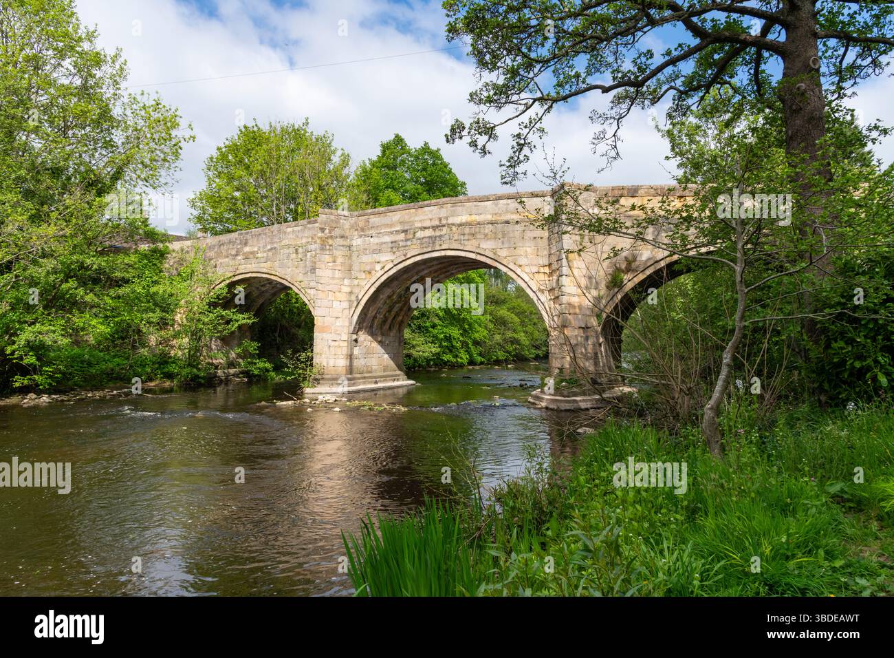Old stone bridge over the river Derwent in the village of Baslow in the ...