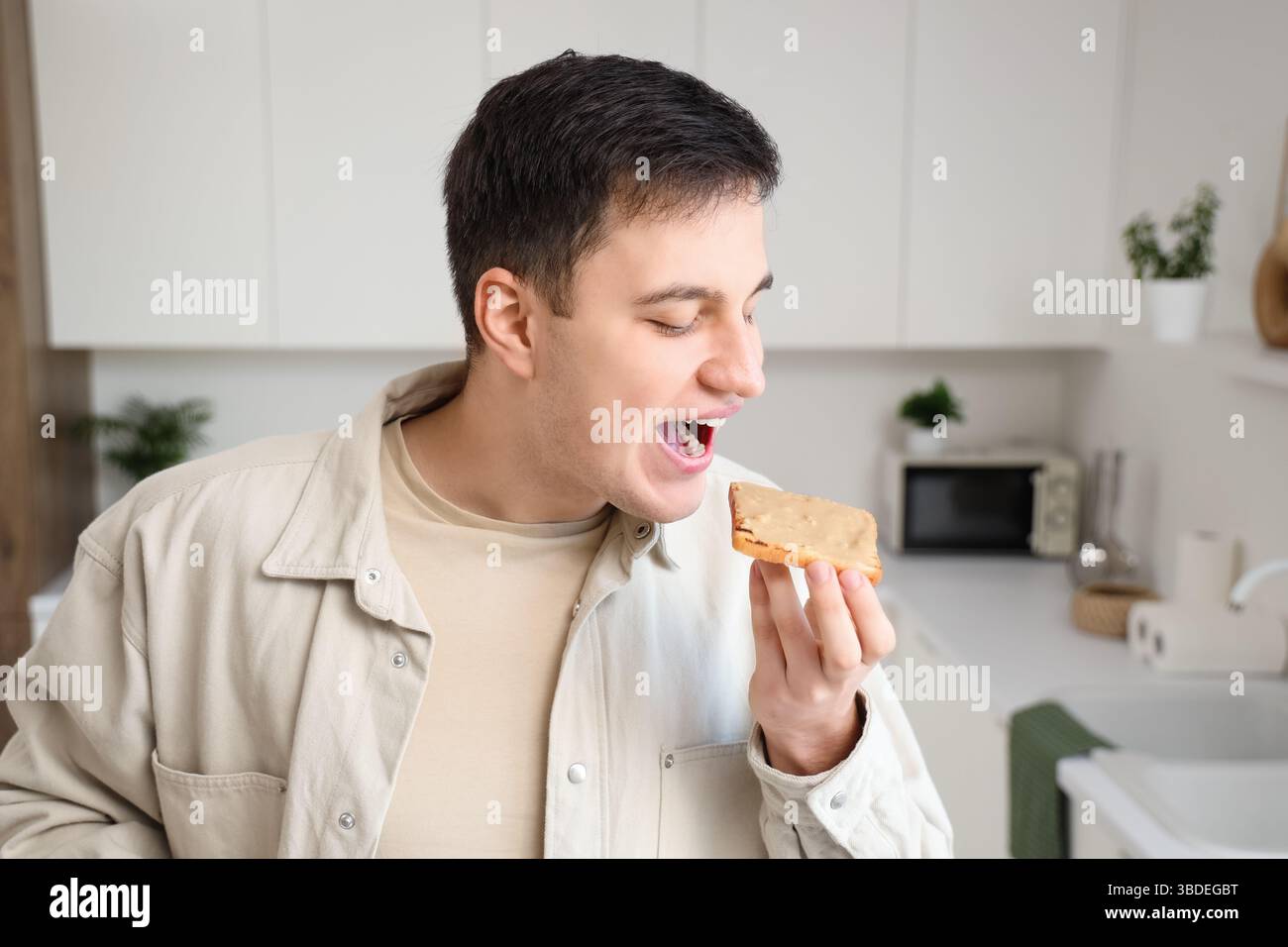 Young man eating peanut butter hi-res stock photography and images - Alamy