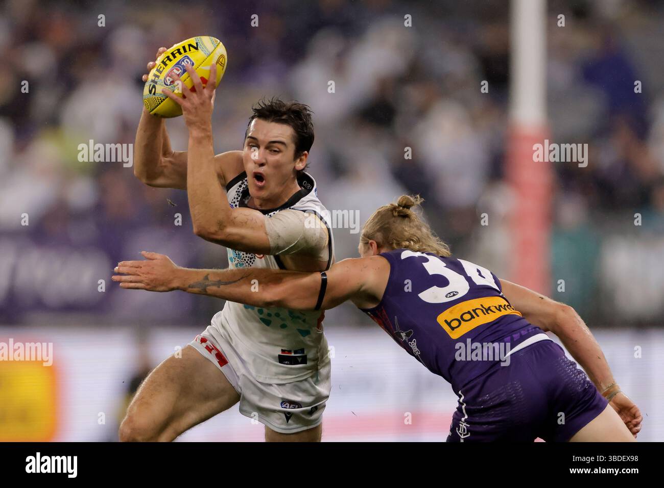 Perth, Australia. 24th May, 2025. Connor Rozee of the Power is tackled ...