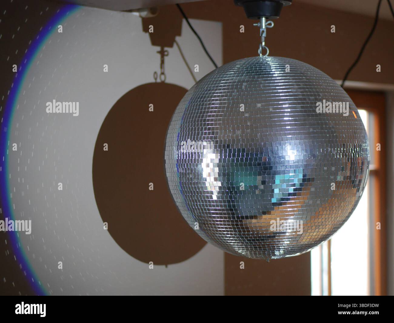 Silver disco ball is hanging from the ceiling Stock Photo - Alamy