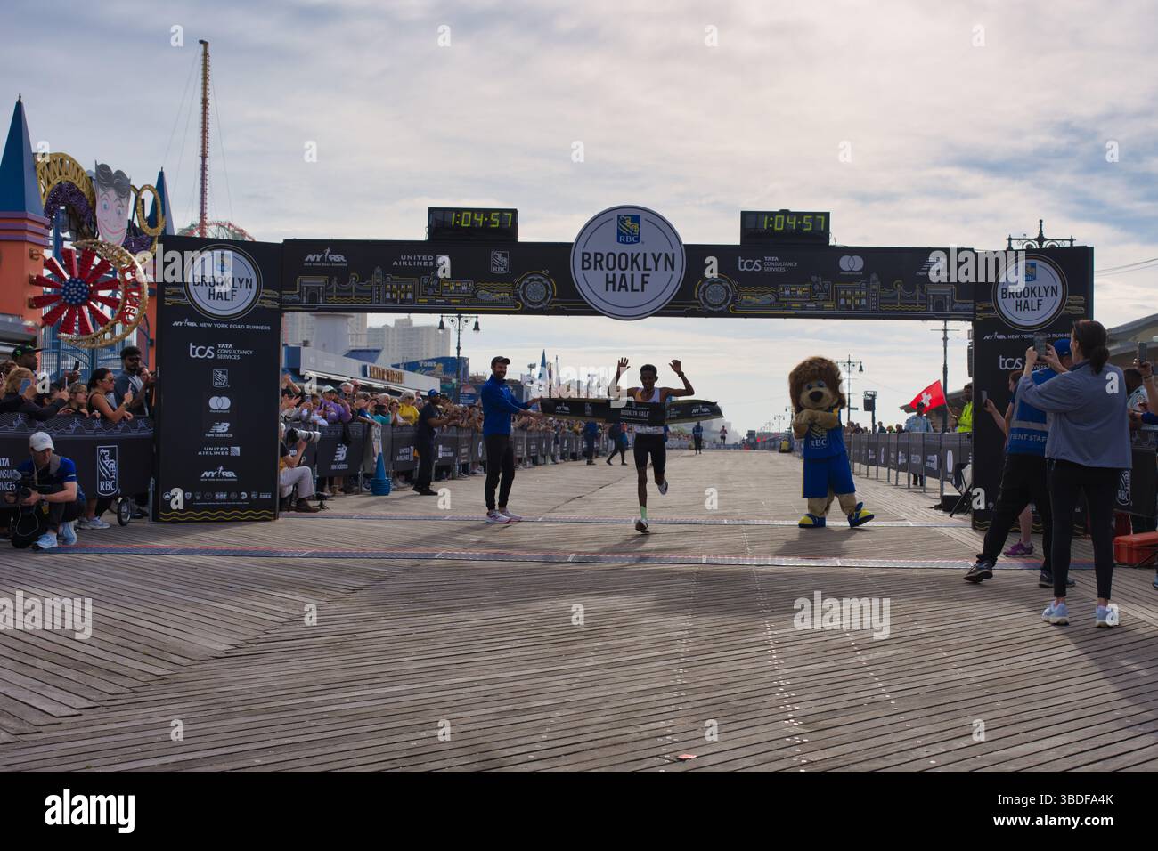 A male runner crosses the finish line at the Brooklyn Half marathon ...