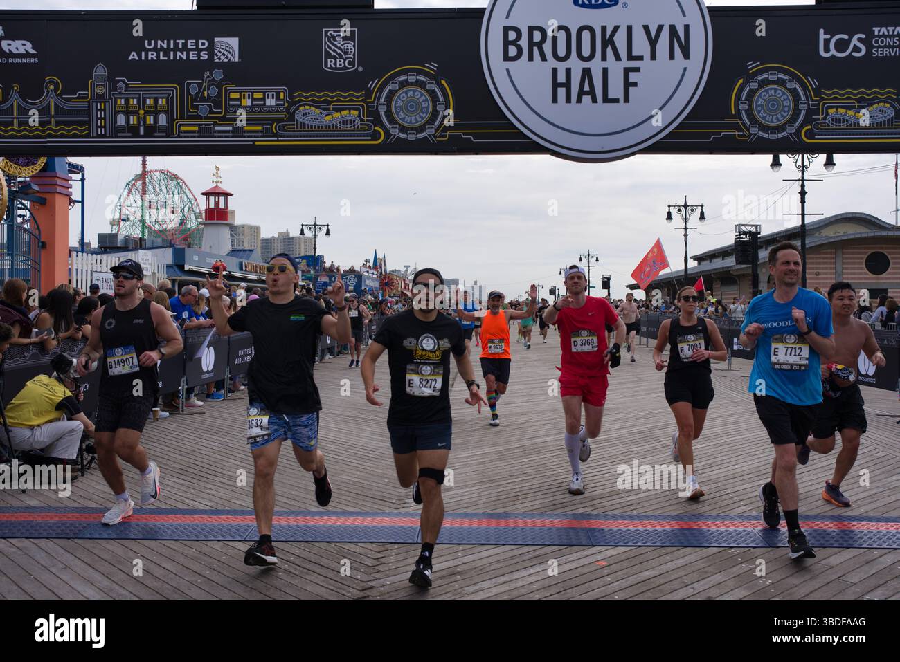 Runners cross the finish line of the Brooklyn Half marathon. The image ...