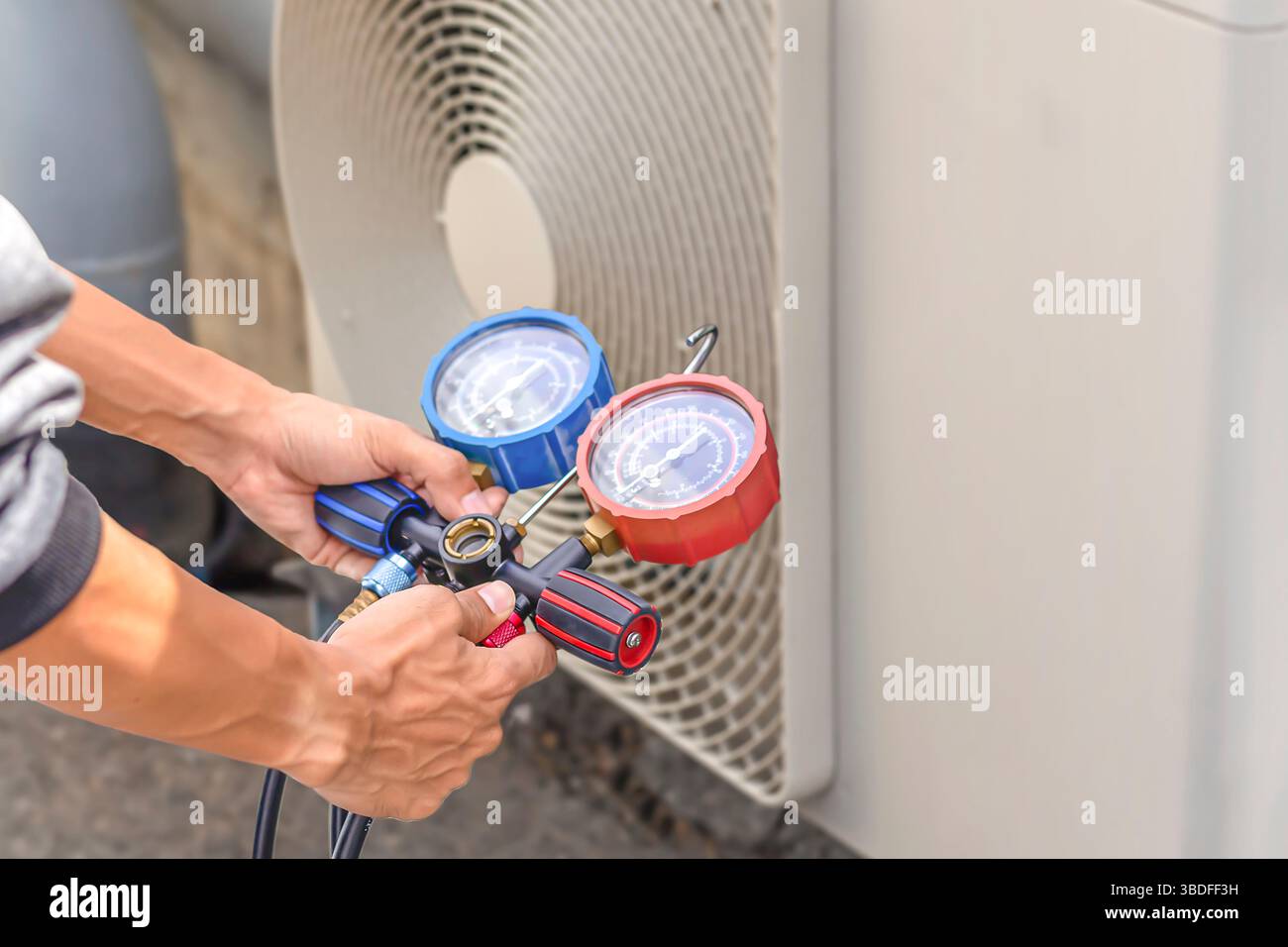 Air conditioning, HVAC service technician using gauges to check ...