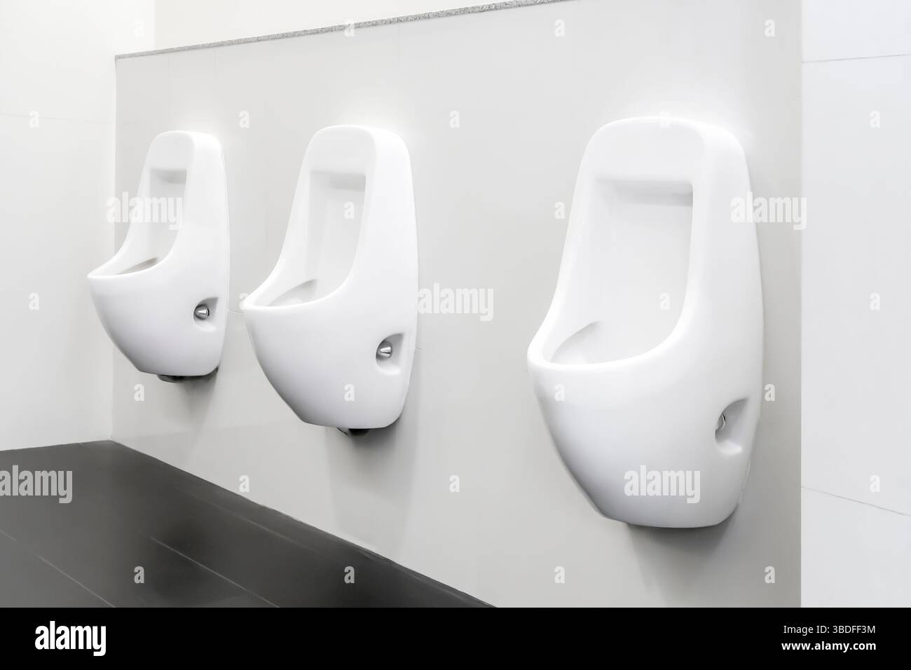 Modern and luxury male urinals on the white wall Stock Photo - Alamy