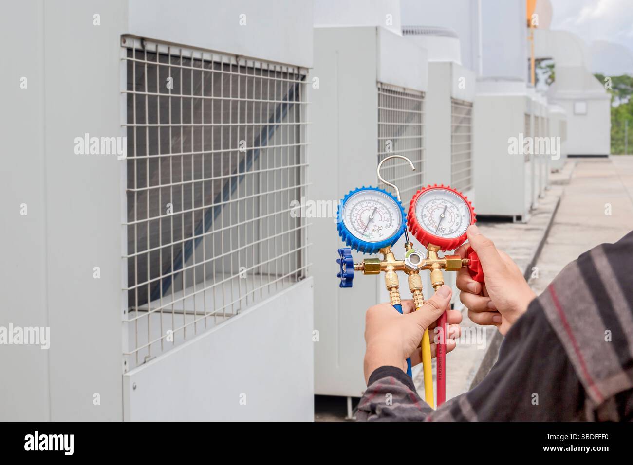 Air conditioning, HVAC service technician using gauges to check ...