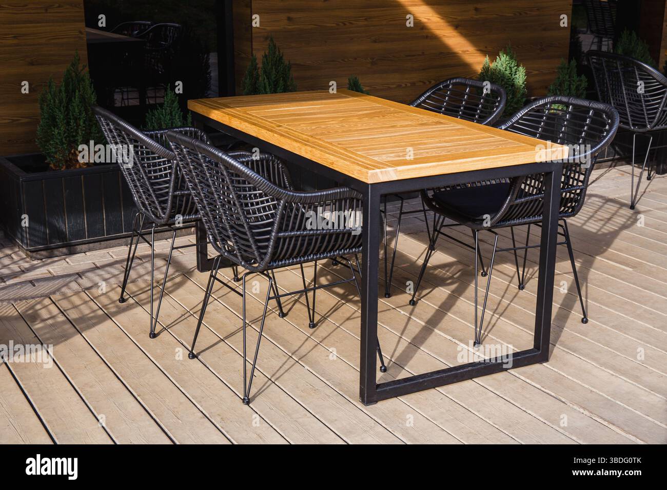 Outdoor wooden dining table with metal chairs in patio or terrace ...