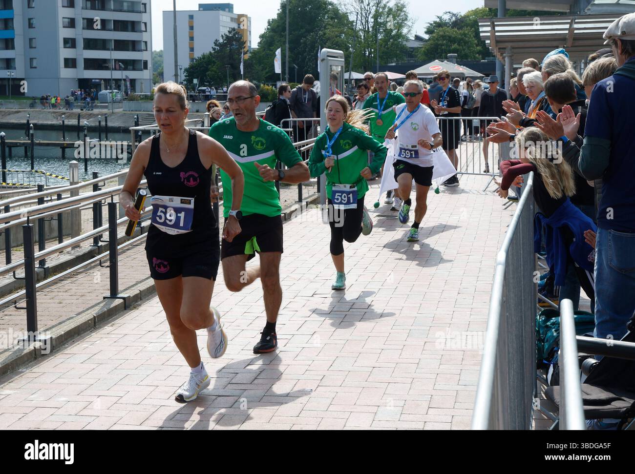 Damp, Germany. 24th May, 2025. A running group crosses the finish line ...