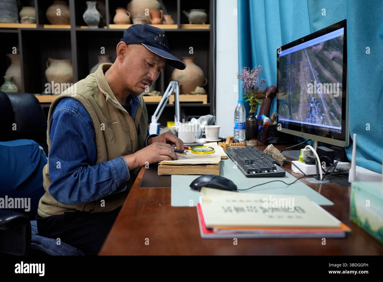 (250524) -- YINCHUAN, May 24, 2025 (Xinhua) -- Li Shixiang reads an ancient book to mark a ...