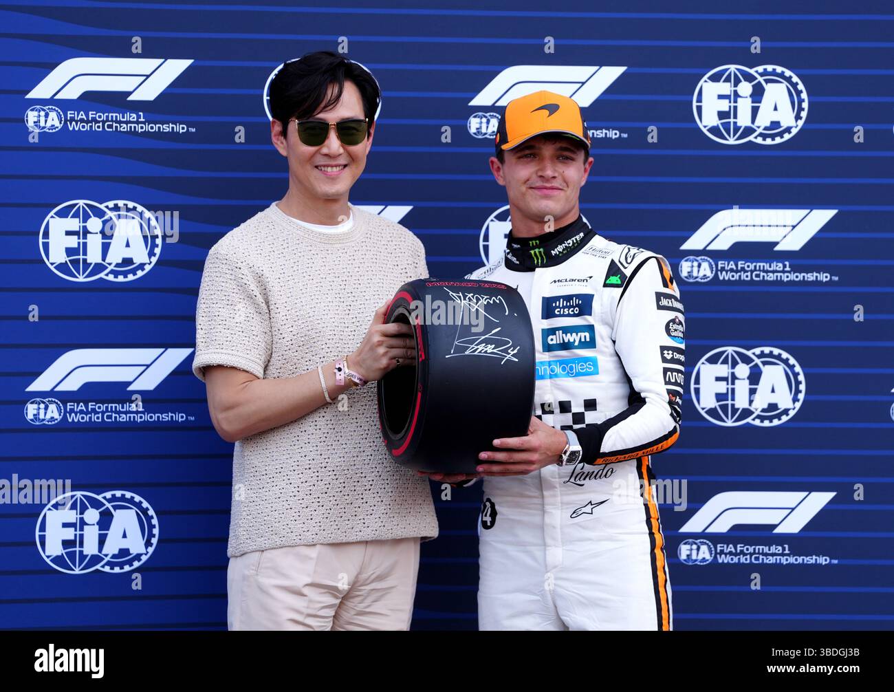 Pole position qualifier McLaren driver Lando Norris (right) receives ...