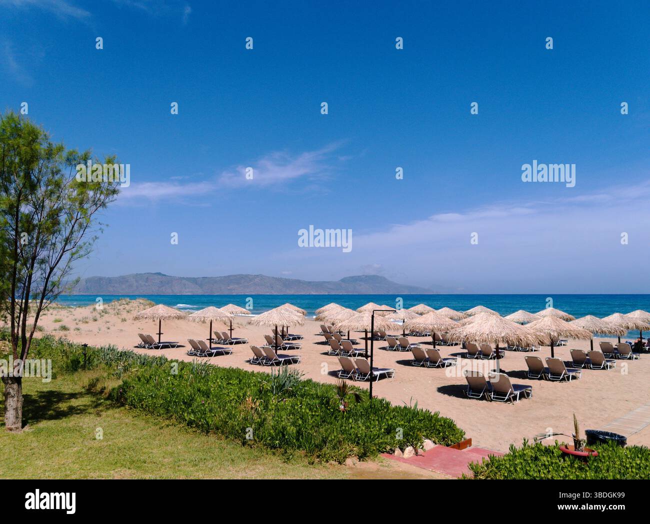Idyllic Episkopi beach, Rethymnon, Crete, Greece. Sun loungers in rows ...