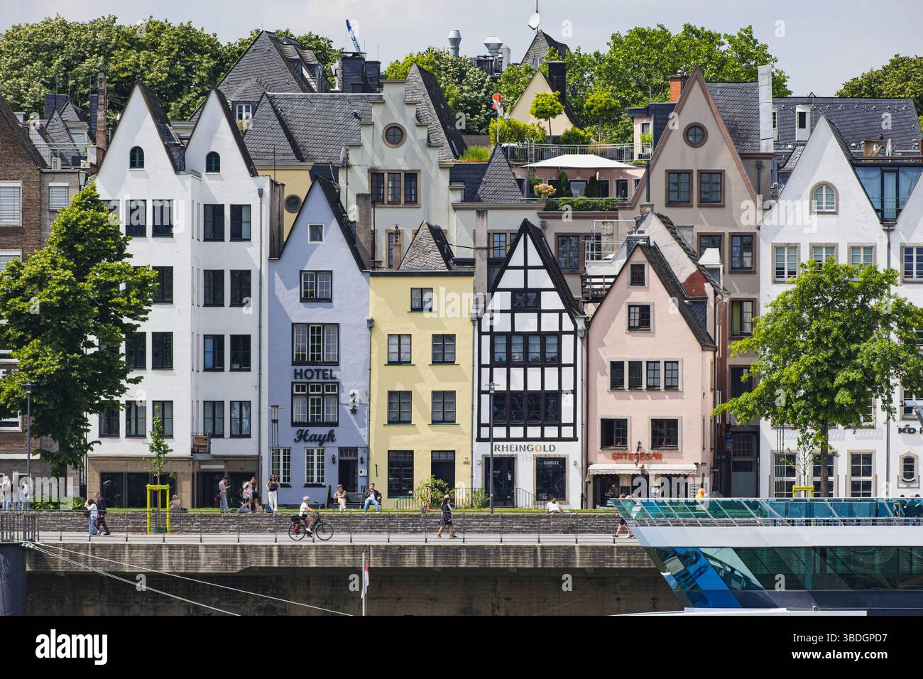 Colorful houses and a river cruise boat along the Cologne waterfront ...