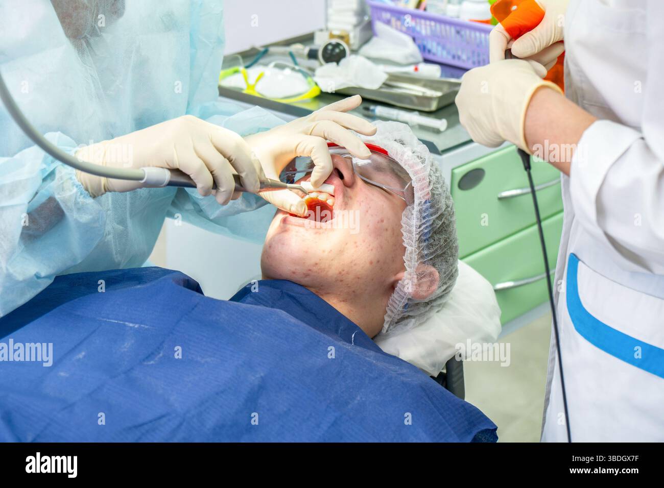 Dental professionals perform a procedure on a patient while ensuring ...