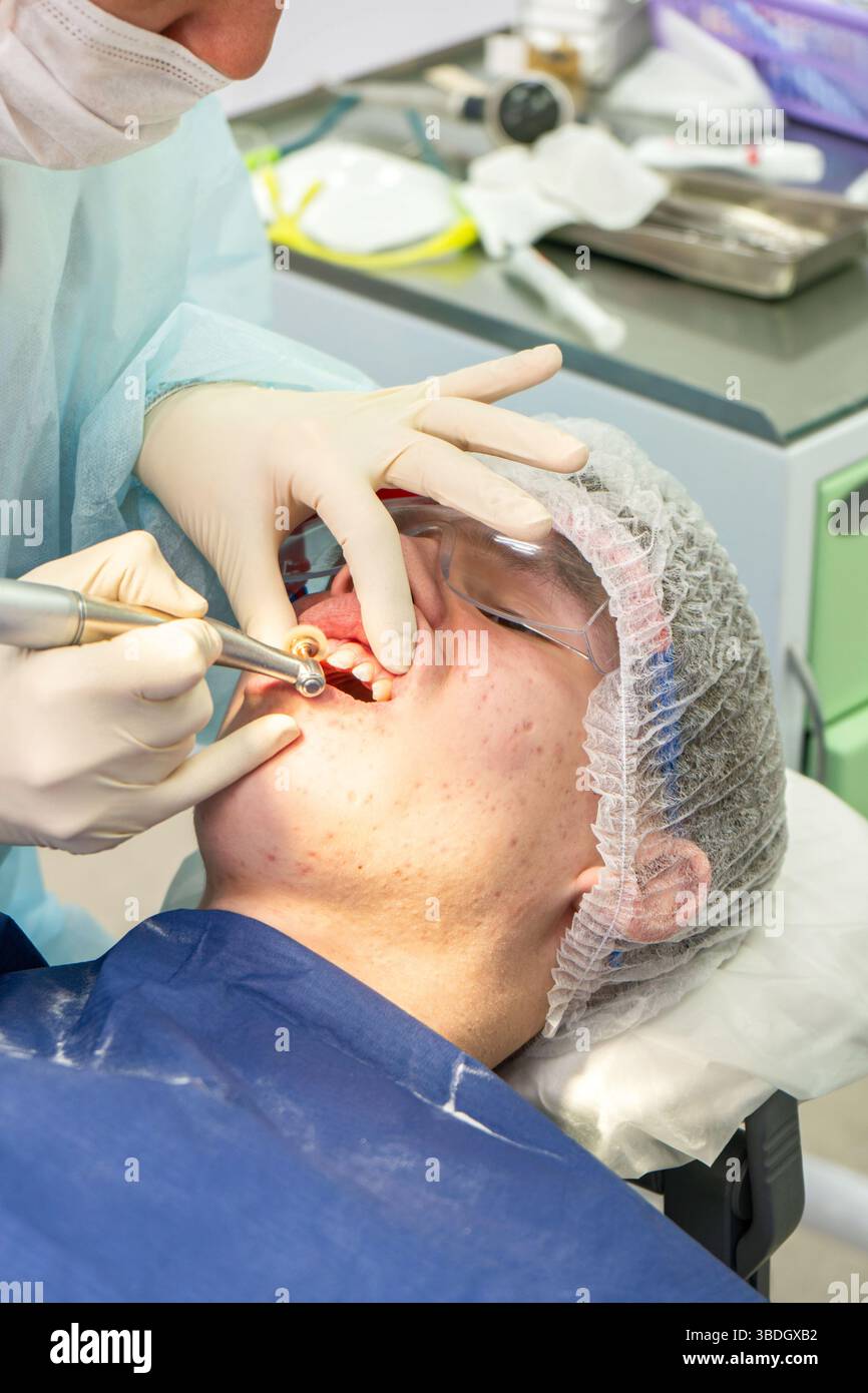 Dental professional performs cleaning procedure on a patient to remove ...
