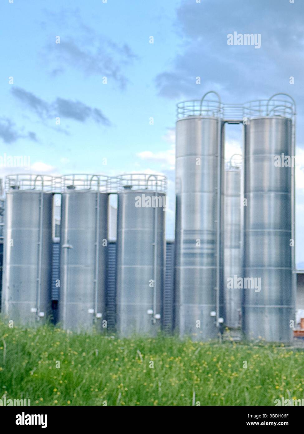 Row of tall silos are lined up in a field Stock Photo - Alamy