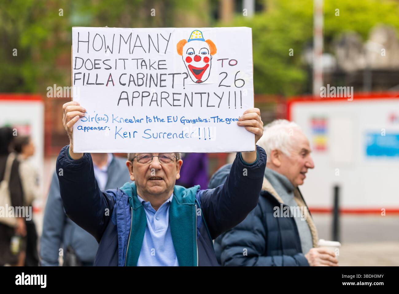 Leeds, UK. 24 MAY, 2025. Man holds "How many clowns" sign as the right ...