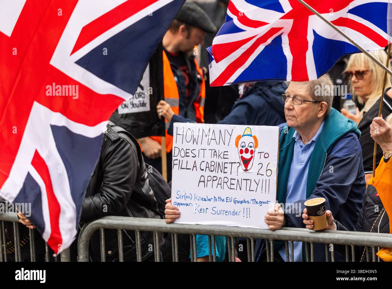 Leeds, UK. 24 MAY, 2025. Man holds "How many clowns" sign as the right ...