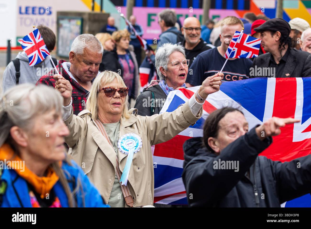 Leeds, UK. 24 MAY, 2025. Lady with reform rossete waves flags as the ...