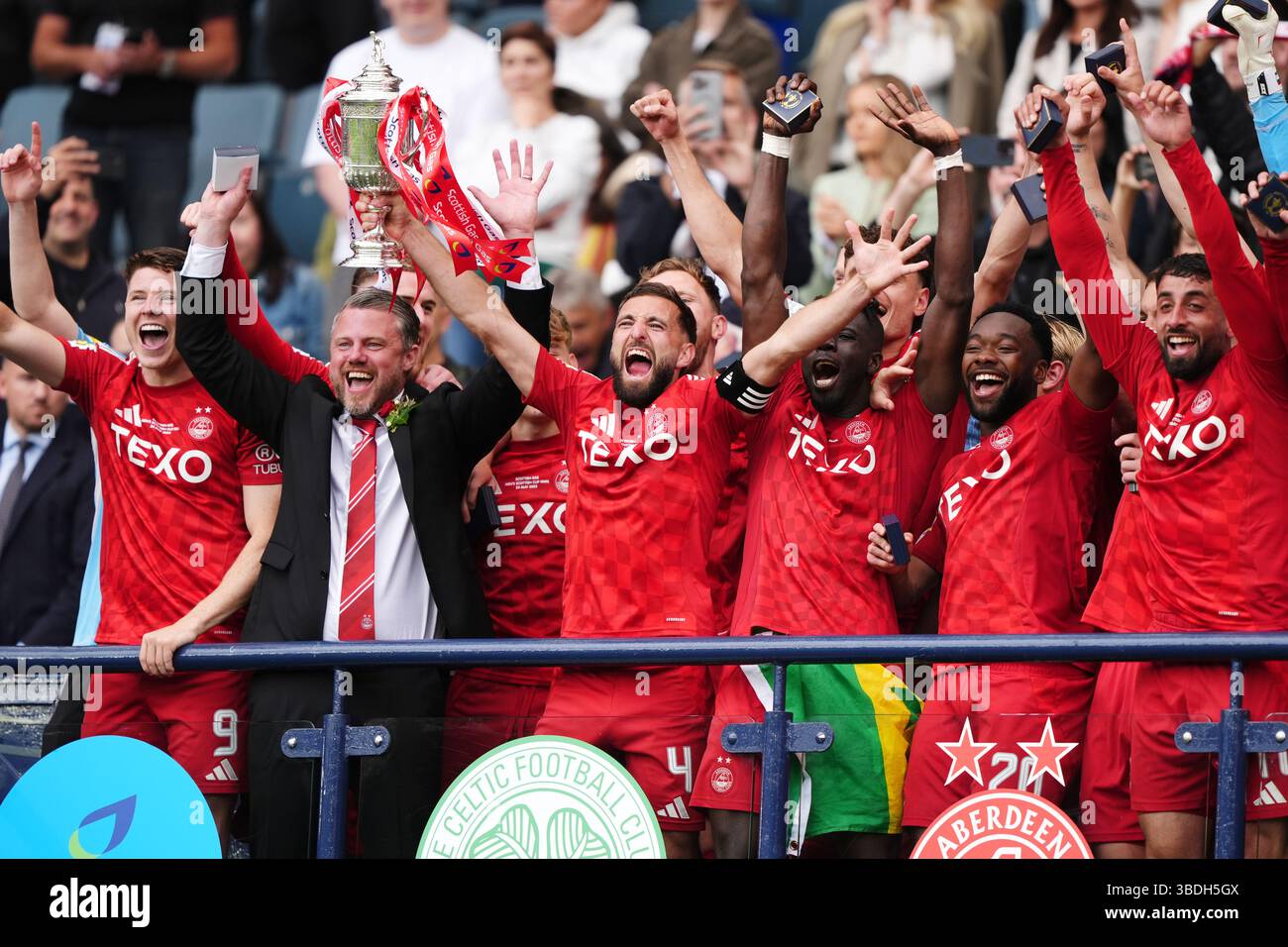Aberdeen's Graeme Shinnie (centre) lifts the trophy after winning the ...